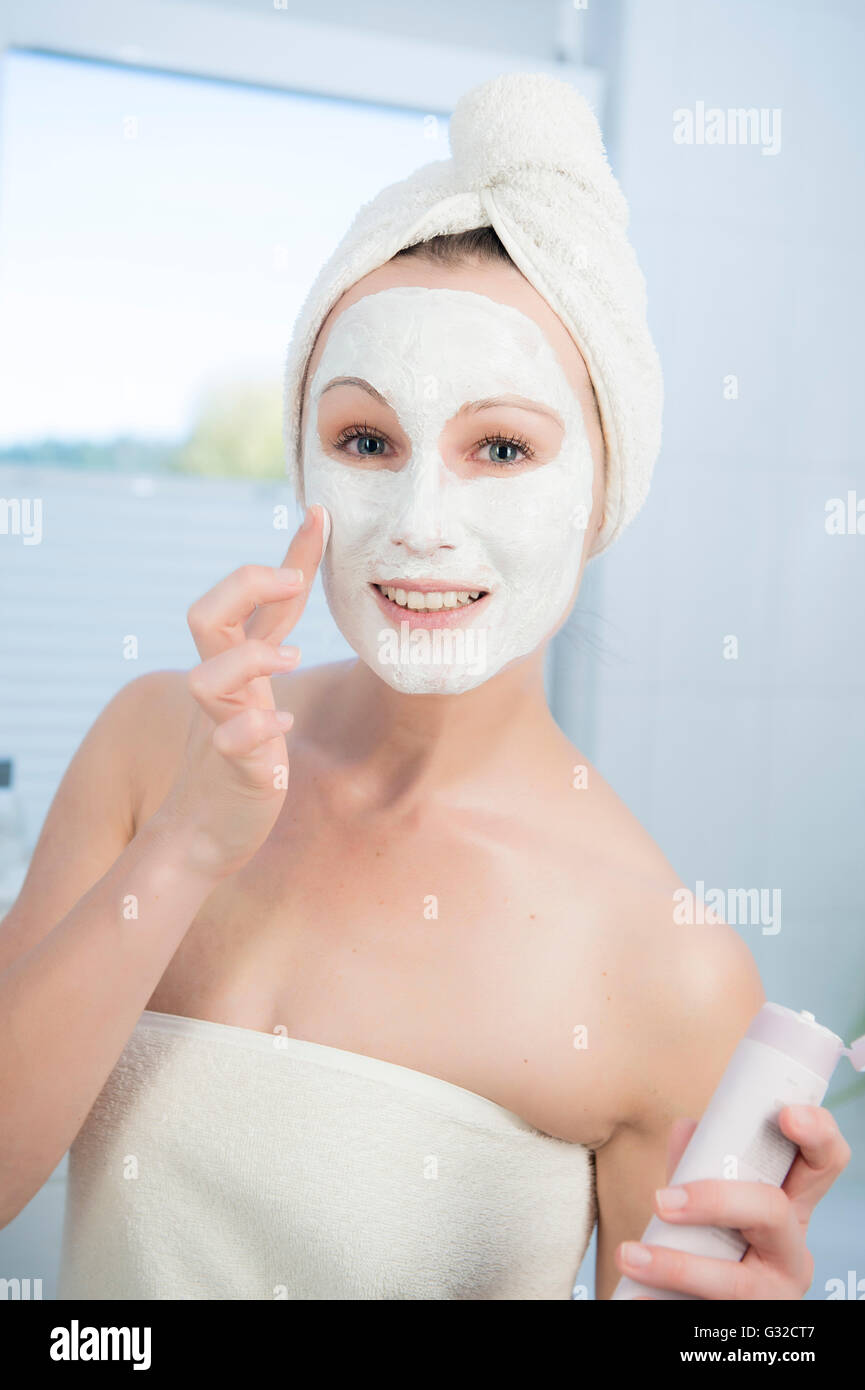 Woman, 30+, in the bathroom applying a facial mask Stock Photo - Alamy