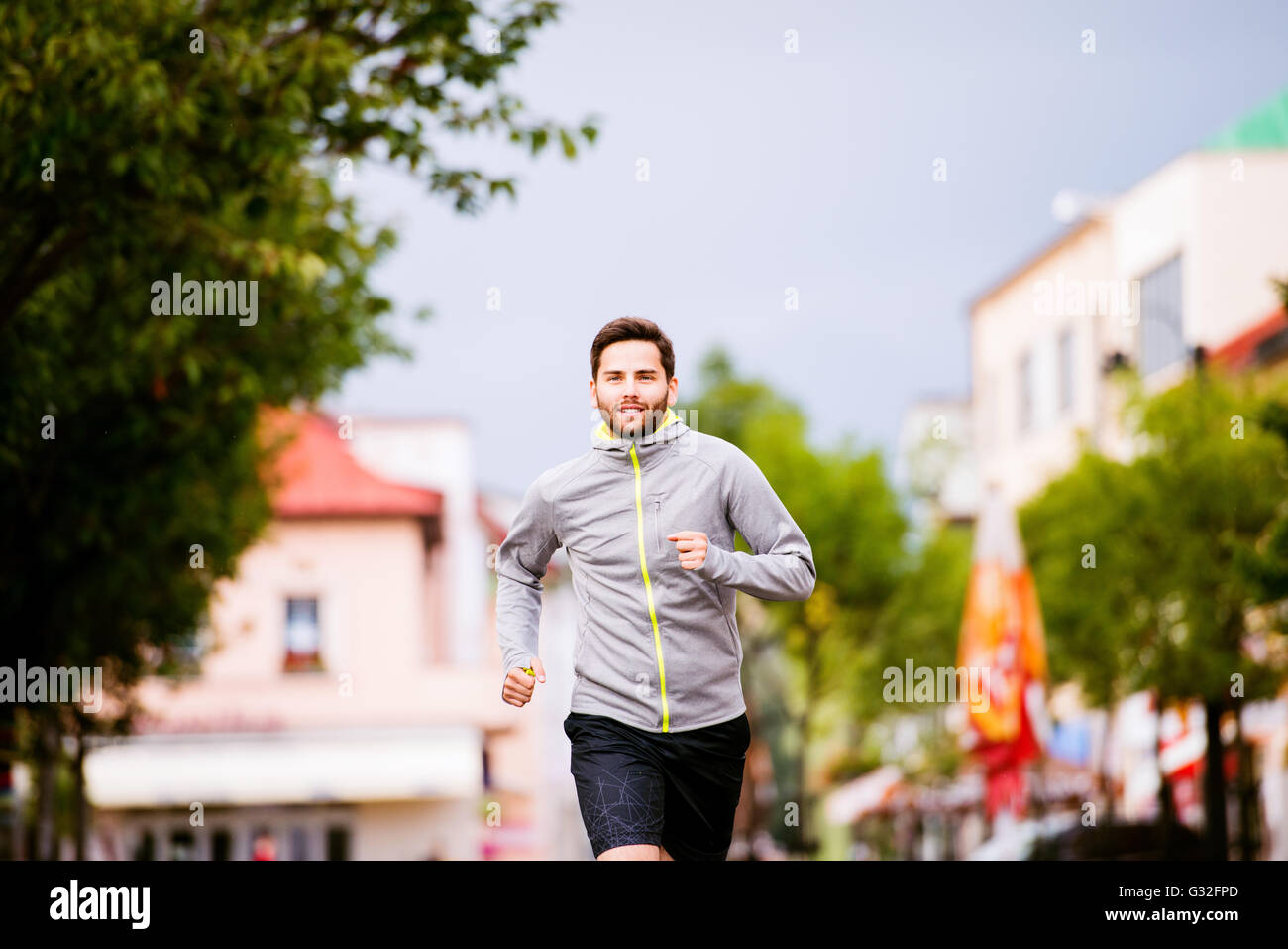 Young hipster man running in town, main street Stock Photo - Alamy