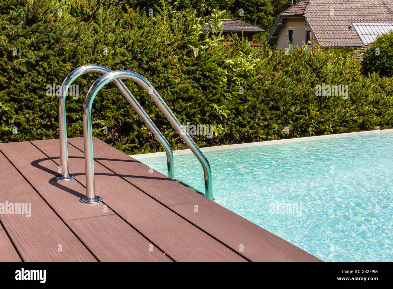 Grab bars ladder in blue swimming pool in a garden in Austria Stock ...