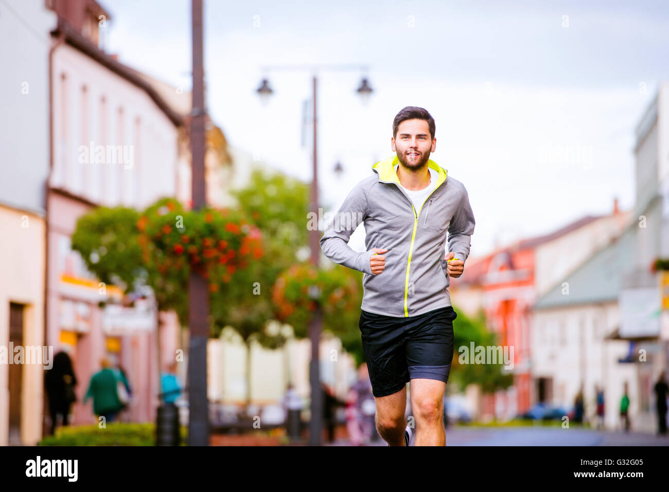 Young hipster man running in town, main street Stock Photo - Alamy