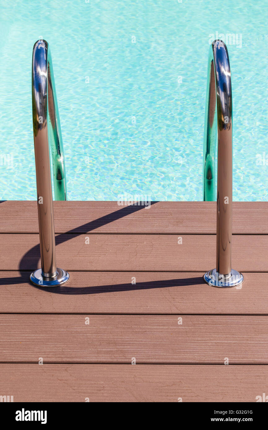 Grab bars ladder in light blue swimming pool Stock Photo - Alamy