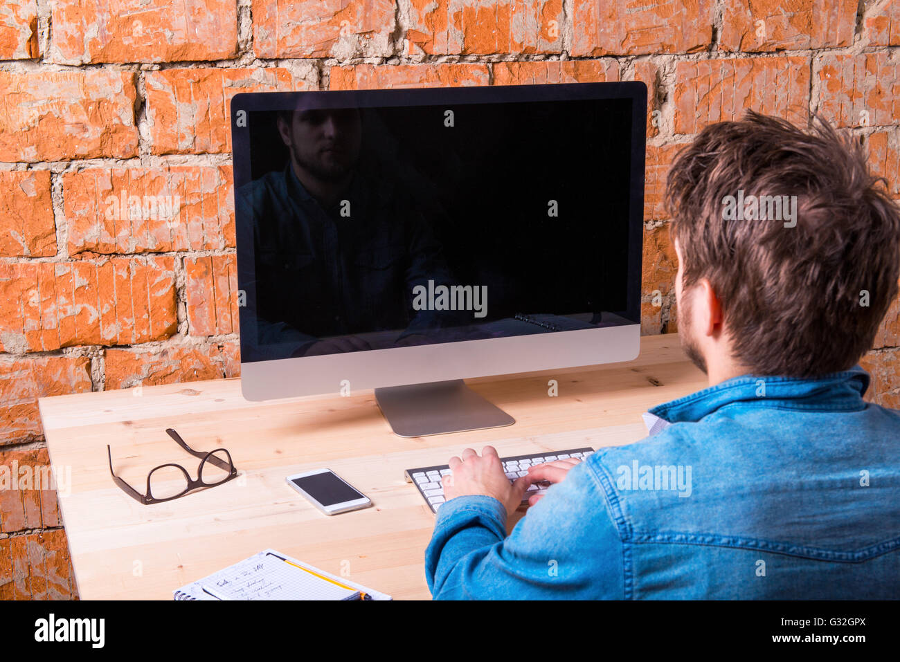 Business person sitting at office desk working, rear view Stock Photo ...