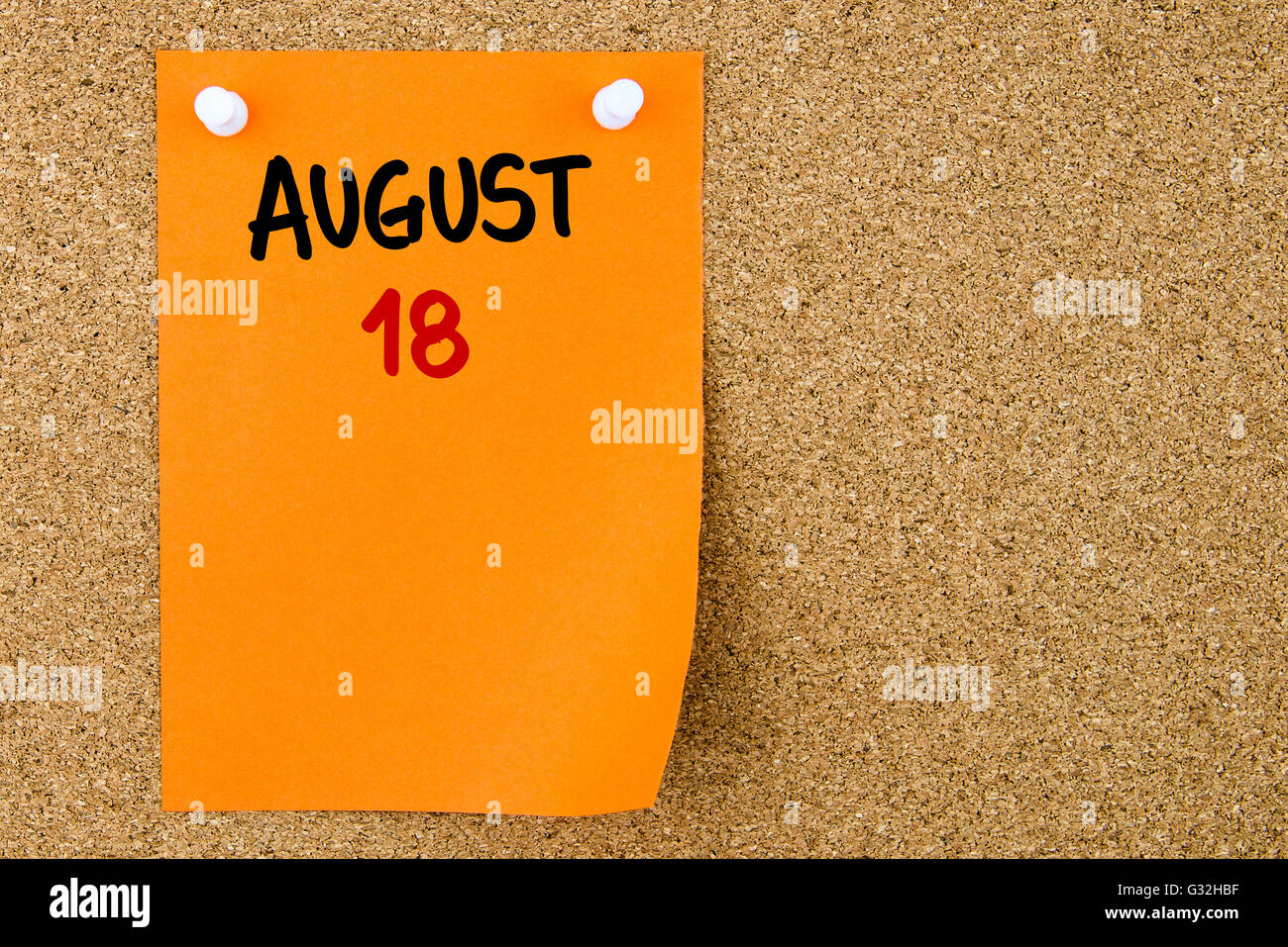 18 AUGUST written on orange paper note pinned on cork board with white ...