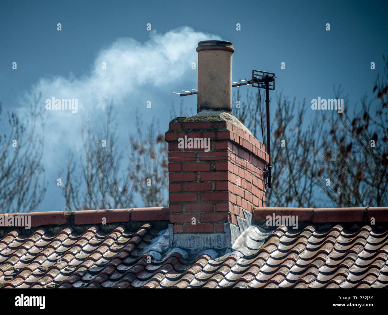 smoke billowing from a chimney pot on a roof top Stock Photo - Alamy