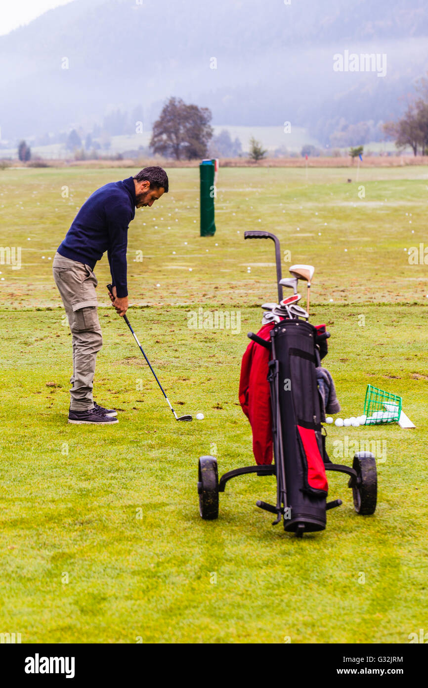 a golf player practicing the swing on the driving range Stock Photo - Alamy