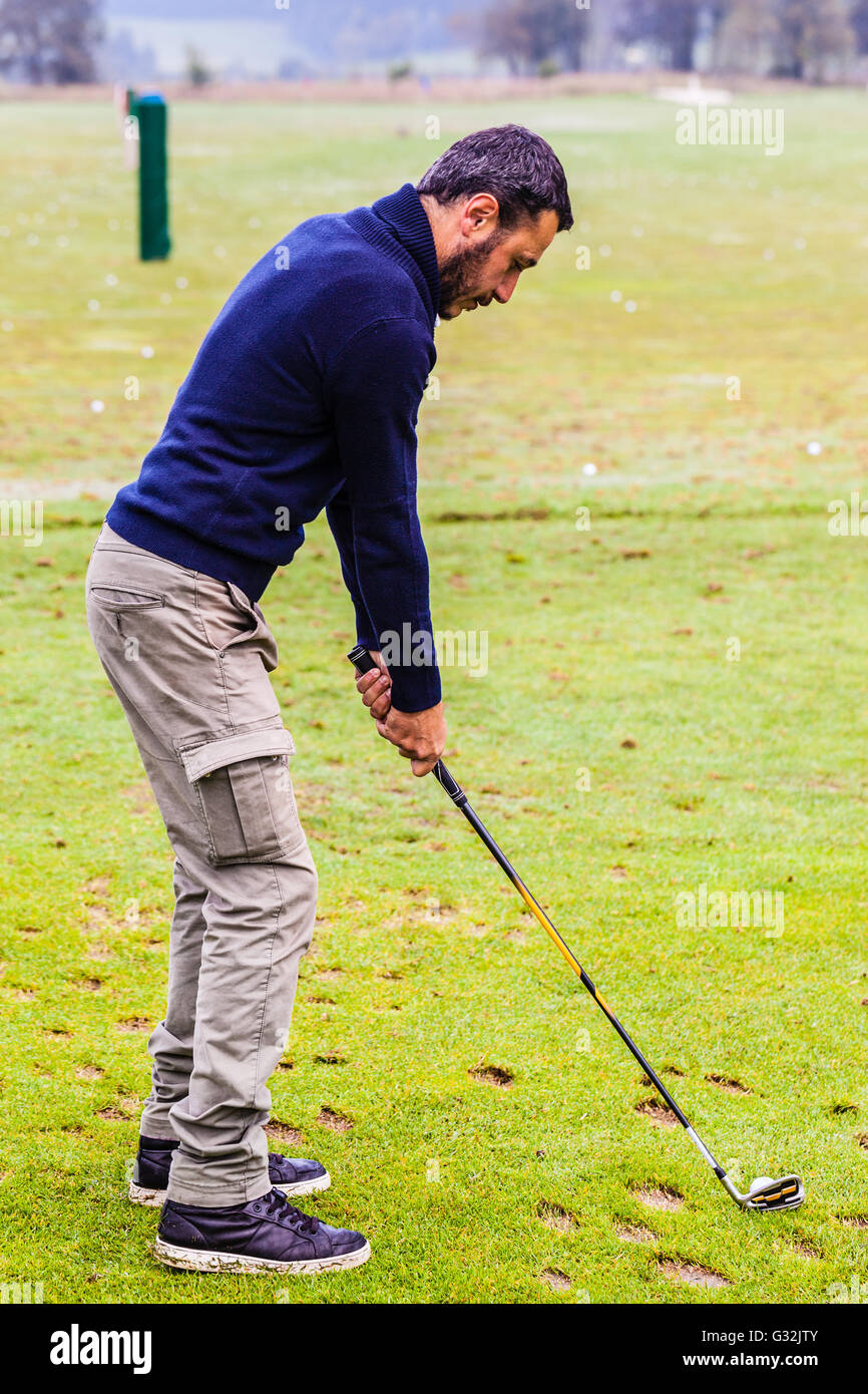 a golf player practicing the swing on the driving range Stock Photo - Alamy
