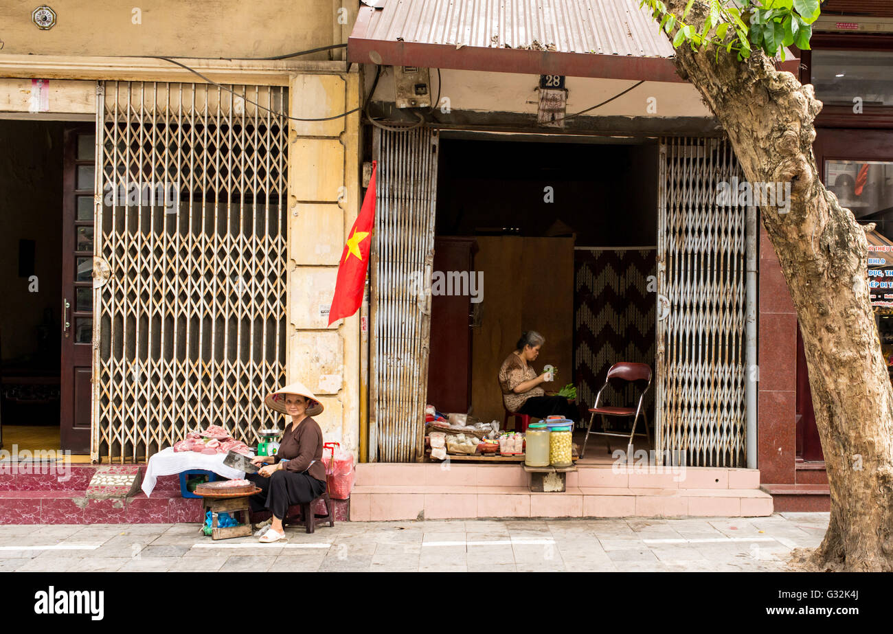 Street vendors selling goods on the street and in small shops in Hanoi ...