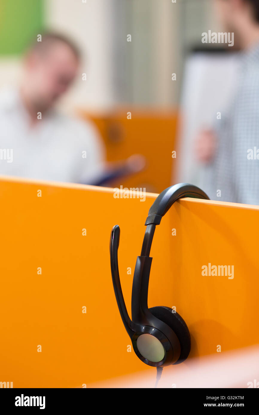 Headphones hanging on cubicle partition in empty office Stock Photo - Alamy