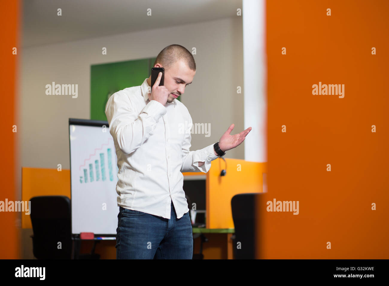 Smiling businessman having mobile phone conversation while standing ...