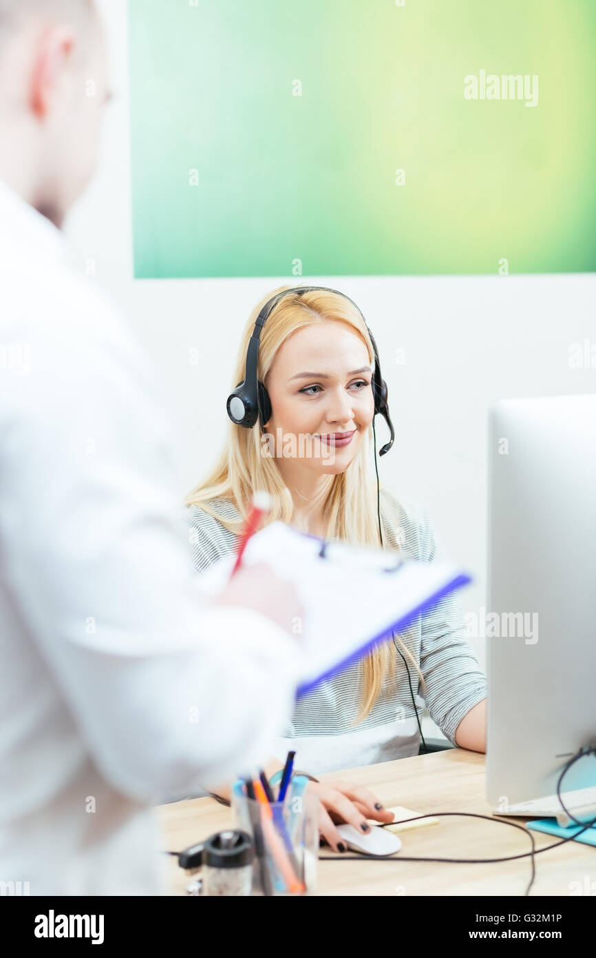 businesswoman talking on the phone while working on her computer at the ...
