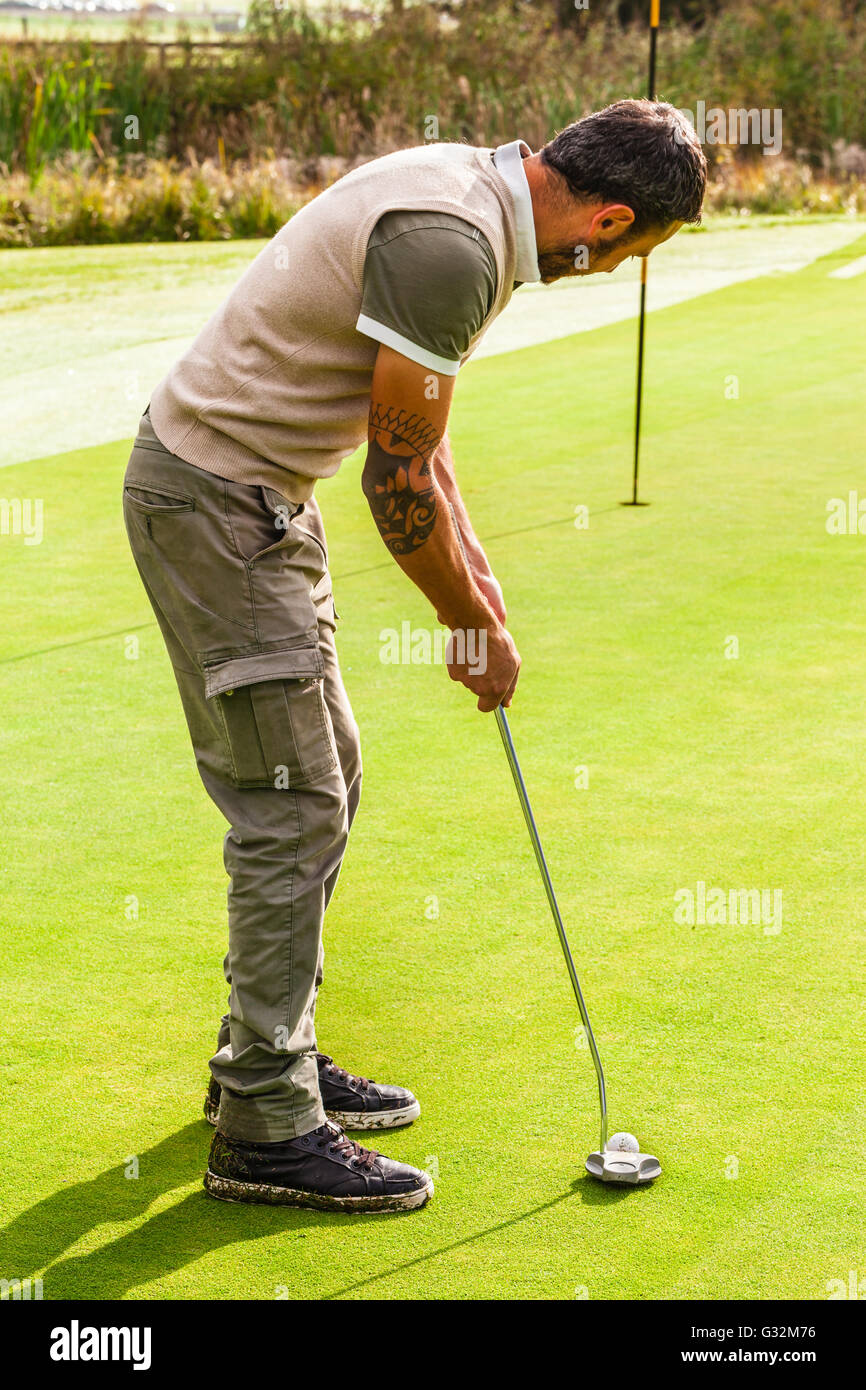 a golf player aiming for the hole on the green with a putter Stock ...