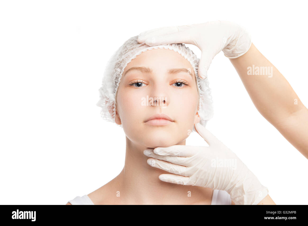 Portrait of young woman in medical hat looking at camera while doctor ...
