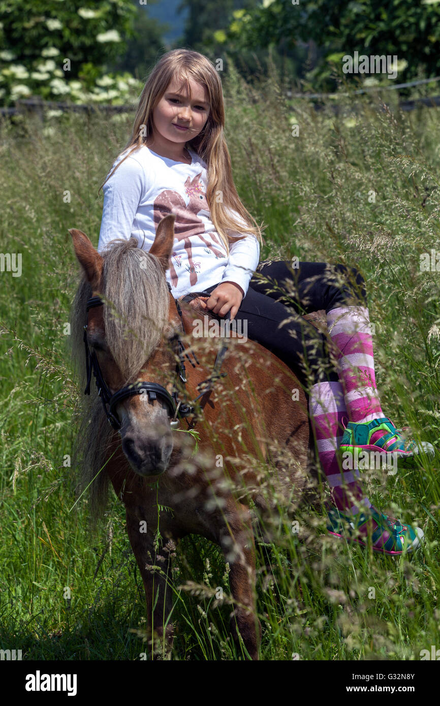Little girl pony, 6 year old girl with her pony in a summer meadow ...