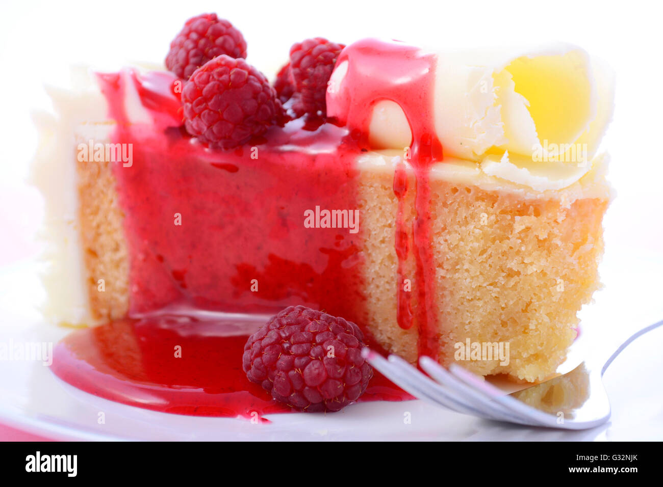 Slice of white chocolate cake with raspberry coulis and fresh ...