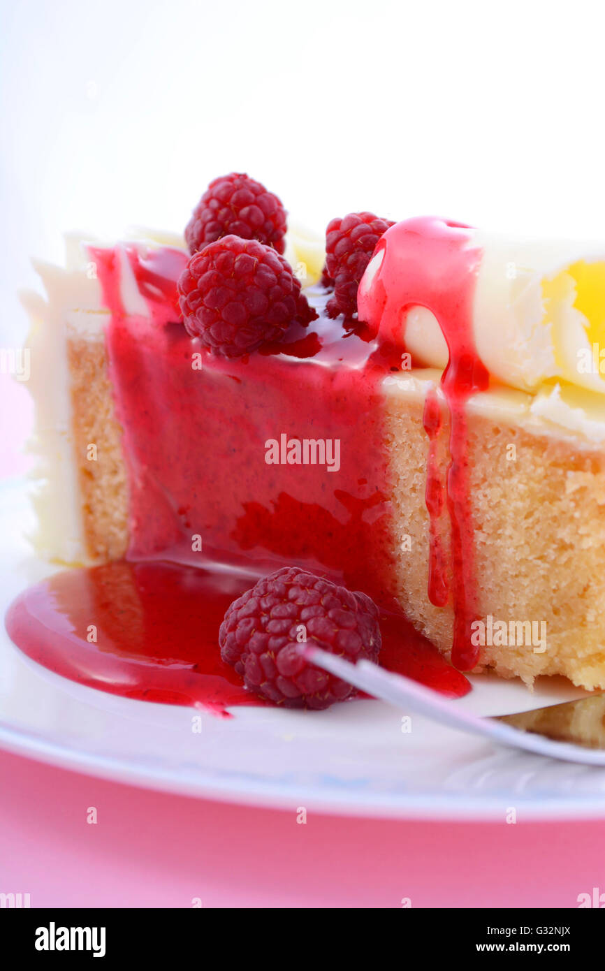 Slice of white chocolate cake with raspberry coulis and fresh ...