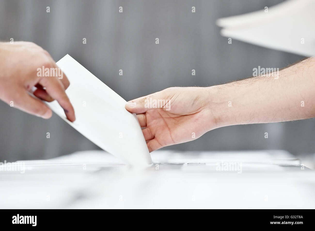 Hand of a person casting a vote into the ballot box during elections ...