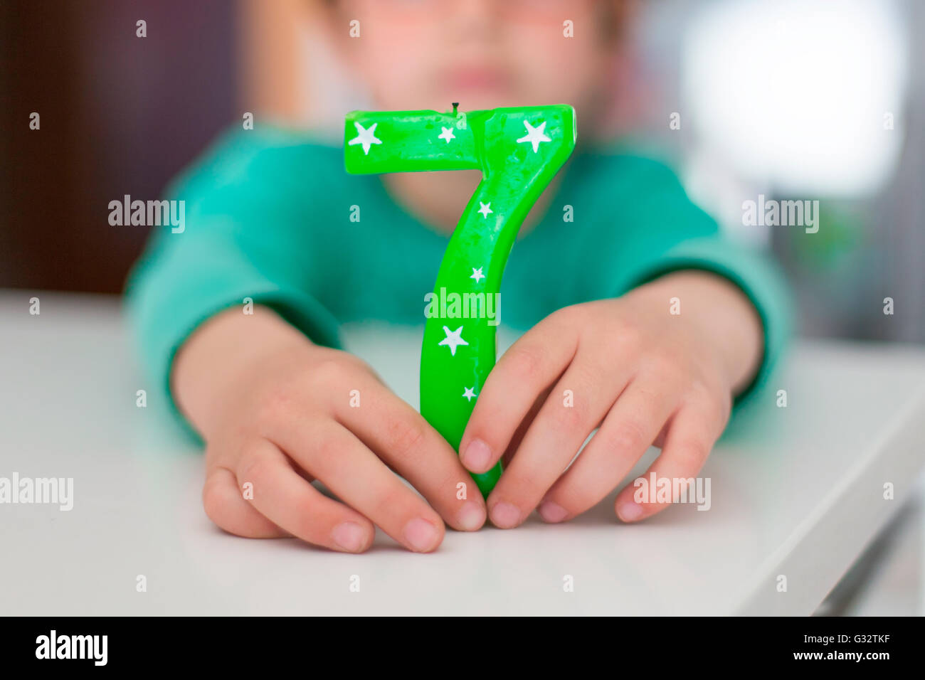 Boy holding number seven birthday candle Stock Photo - Alamy