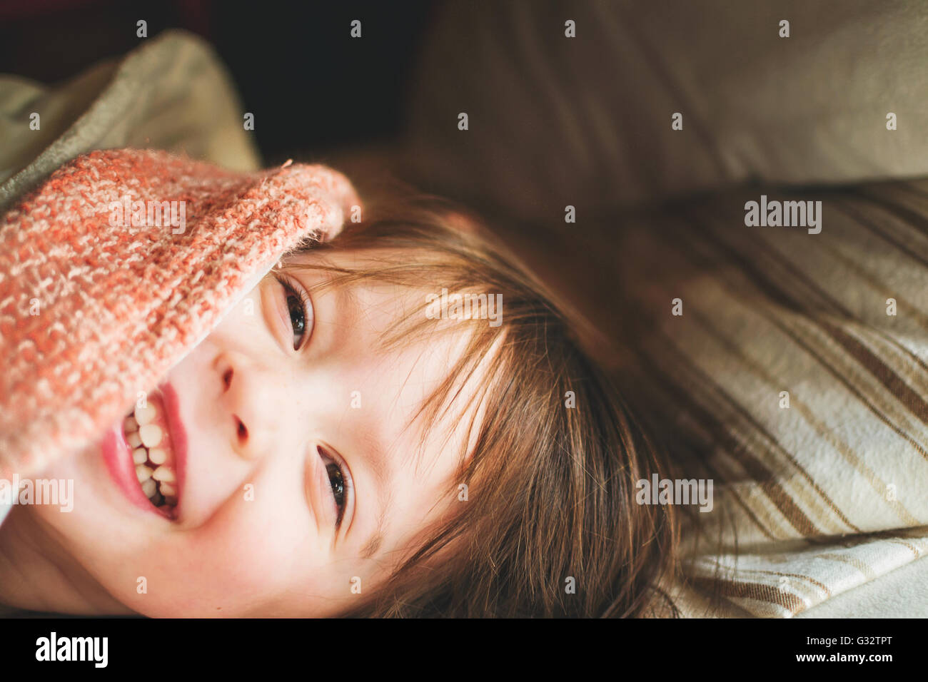 Portrait of a smiling girl lying on a bed Stock Photo - Alamy
