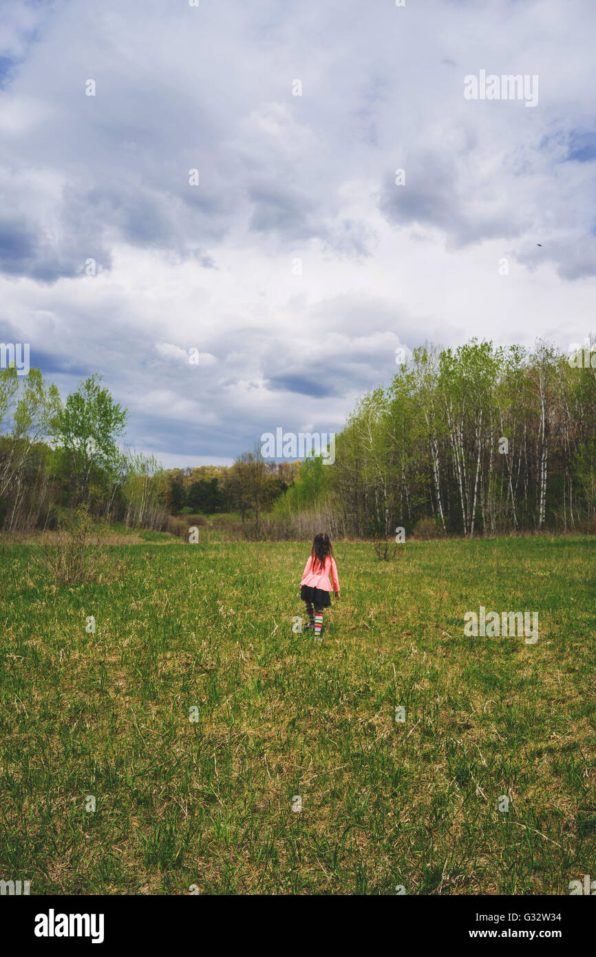 Girl walking in meadow Stock Photo - Alamy