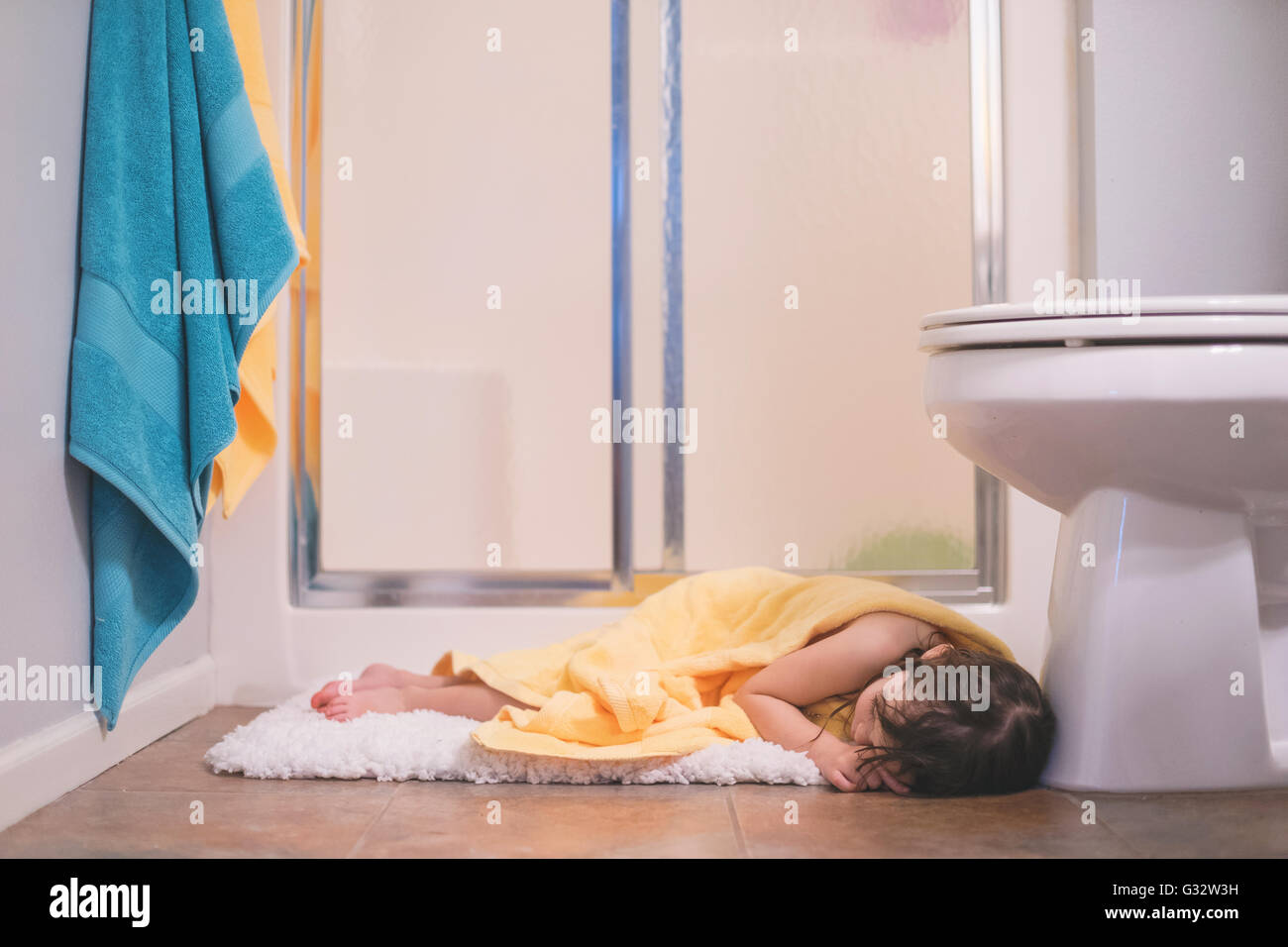 Girl sleeping on bathroom mat Stock Photo - Alamy