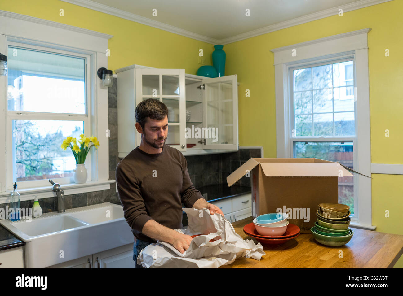 Man packing up plates for house move Stock Photo - Alamy