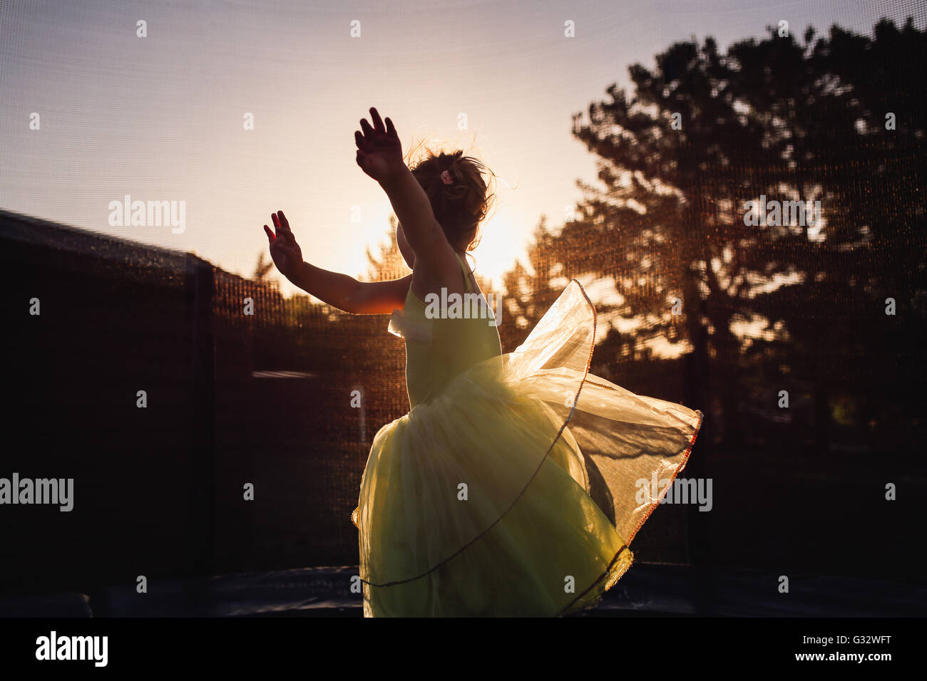 Girl spinning around in garden at sunset Stock Photo - Alamy