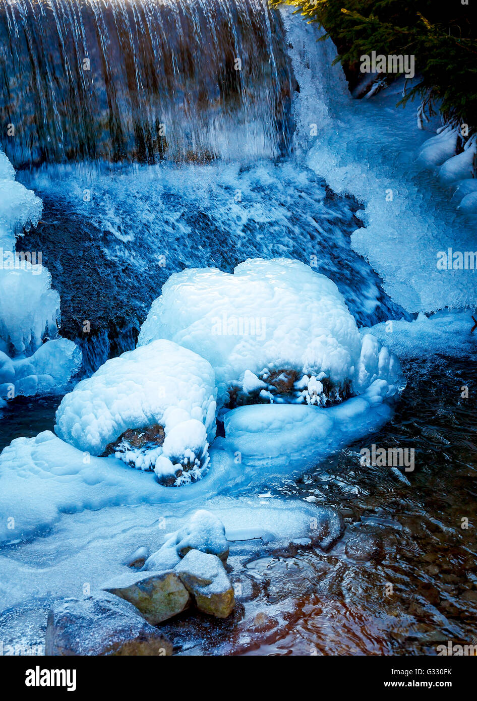 Winter scene with water falling from icy rocks Stock Photo - Alamy