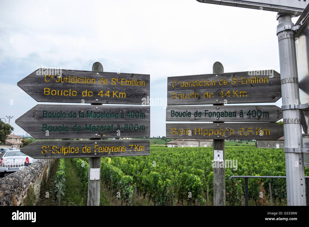 Road signs at a junction in St Emilion, Bordeaux with rows of vines in ...