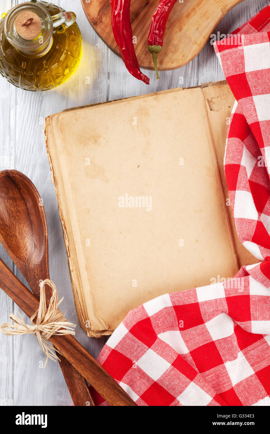 Kitchen table with cookbook, utensils and ingredients. Top view with ...