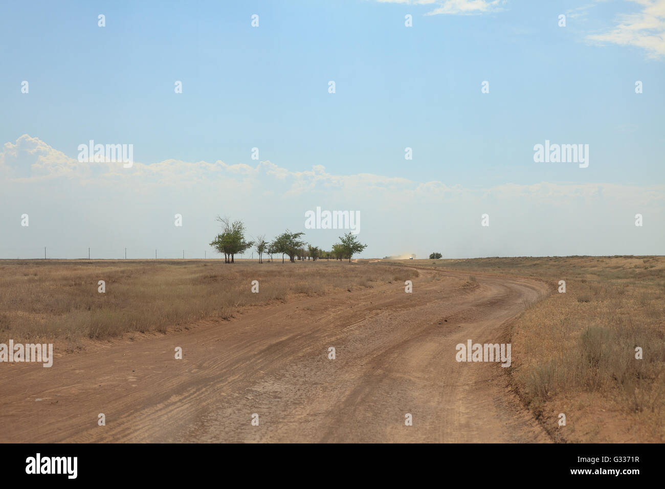 Sandy country road in the salt desert landscape on a hot summer day ...