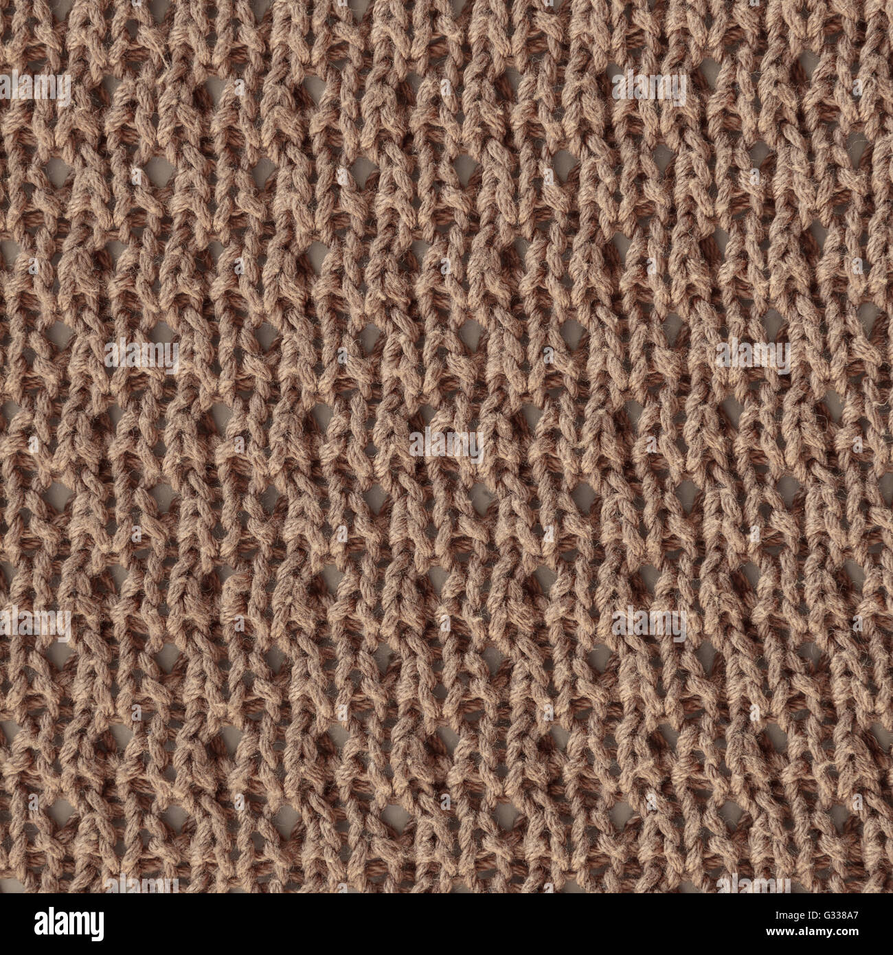Pastel brown wool knitted fabric texture. Close up fragment of the top ...