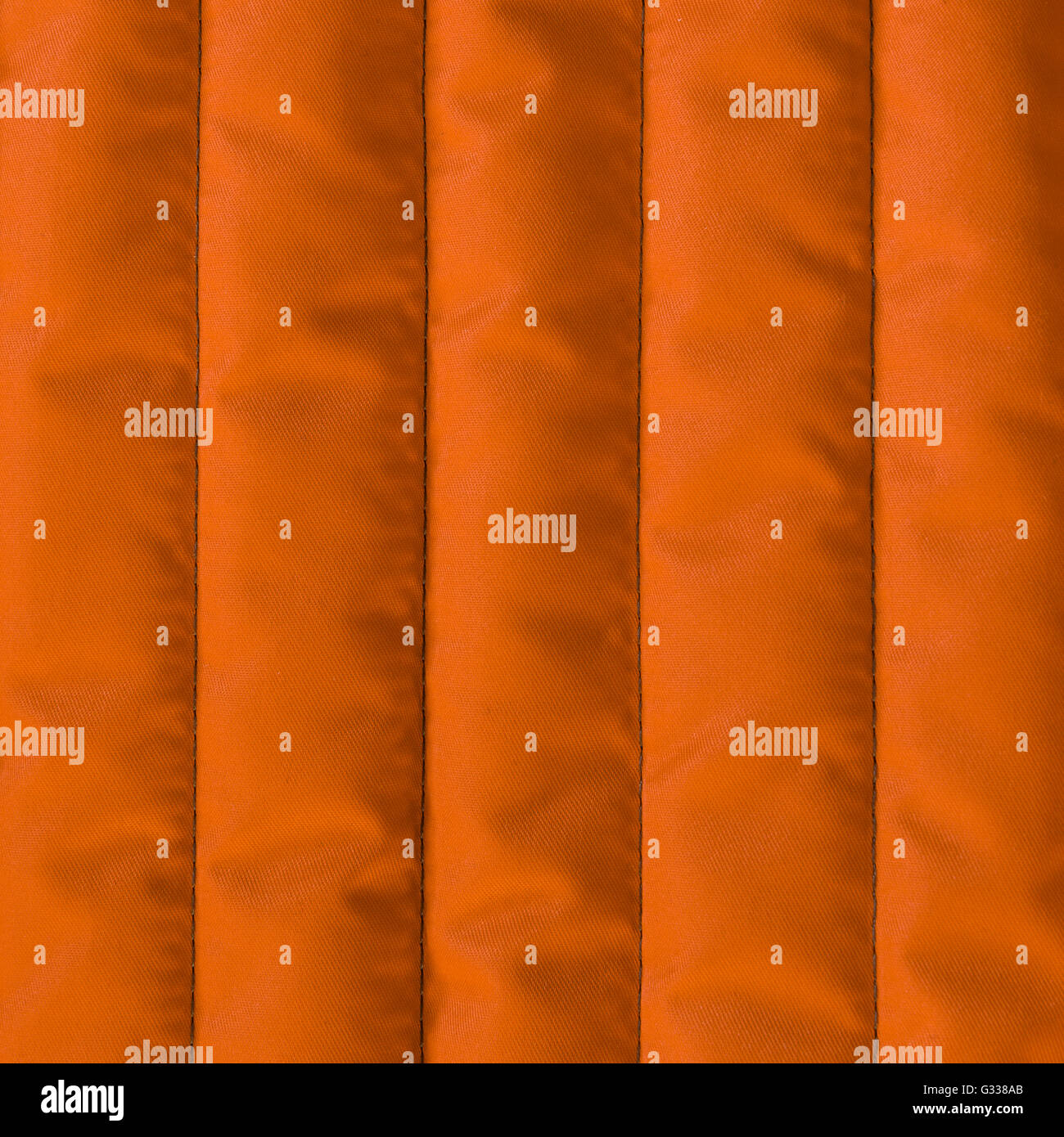 Orange quilted textiles with insulation. Vertical stripes. Close up ...