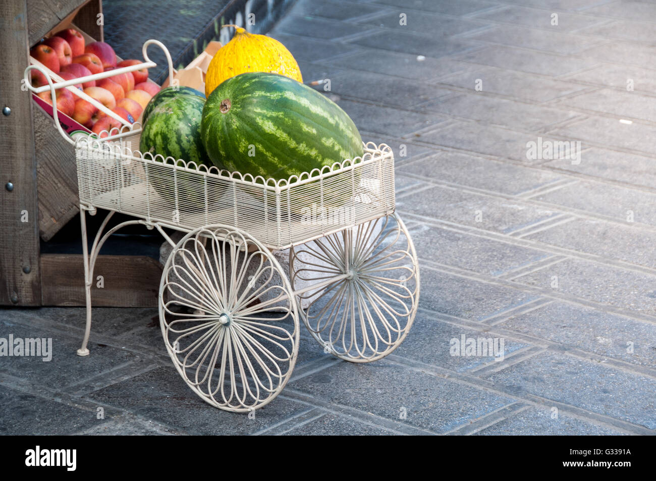 Watermelons and melons in decorative fruit basket stand at a market ...