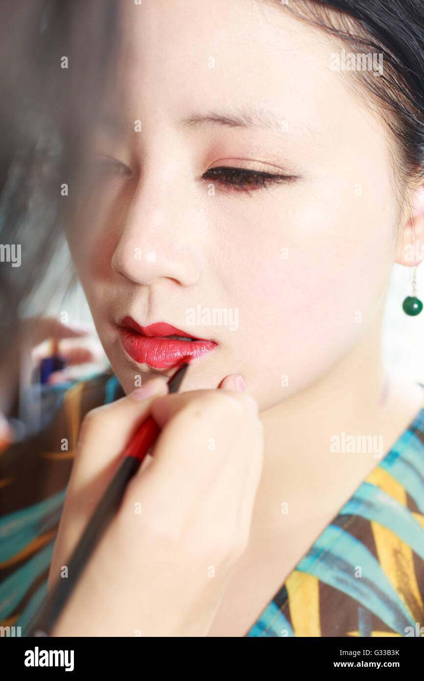 Asian girls are making up face feature Stock Photo - Alamy
