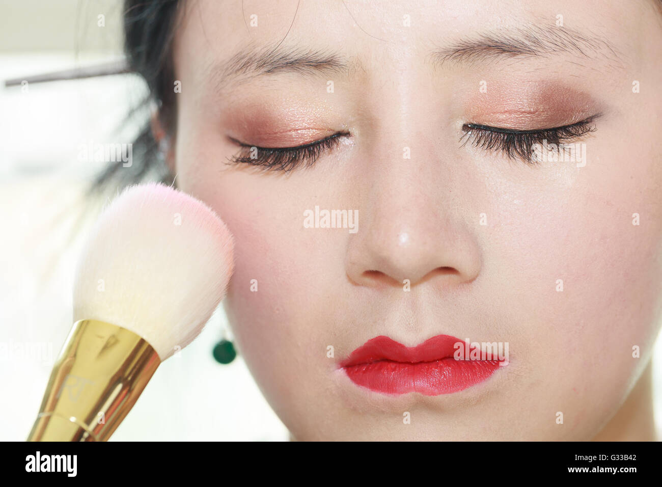 Asian girls are making up face feature Stock Photo - Alamy