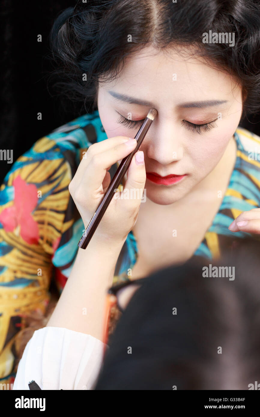 Asian girls are making up face feature Stock Photo - Alamy