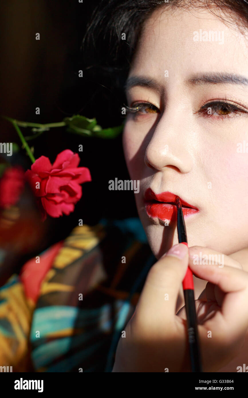 Asian girls are making up face feature Stock Photo - Alamy