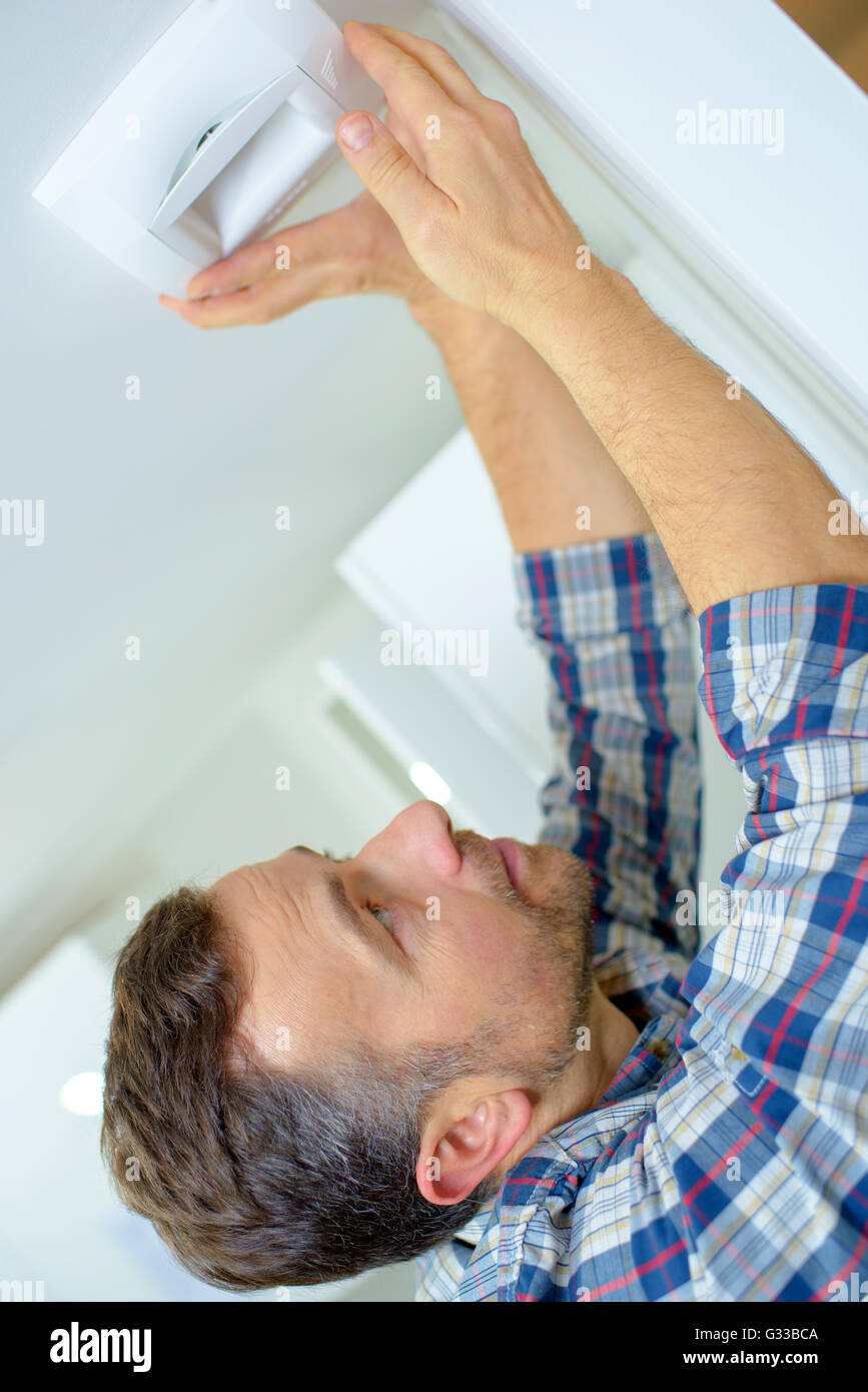 Man fitting an air vent Stock Photo - Alamy