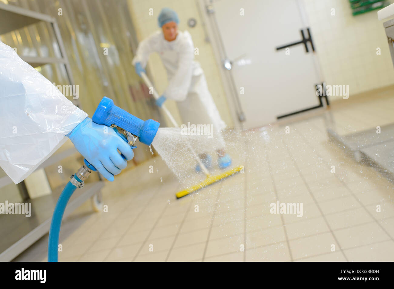 Workers cleaning down factory floor Stock Photo - Alamy