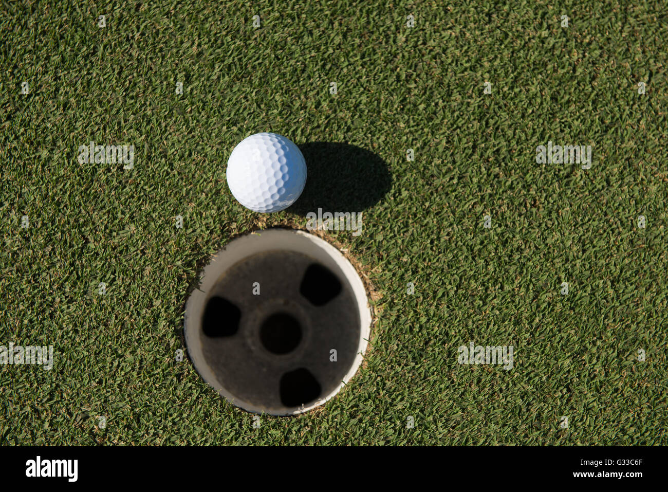 top view of golf ball on edge of course hole representing achivement ...