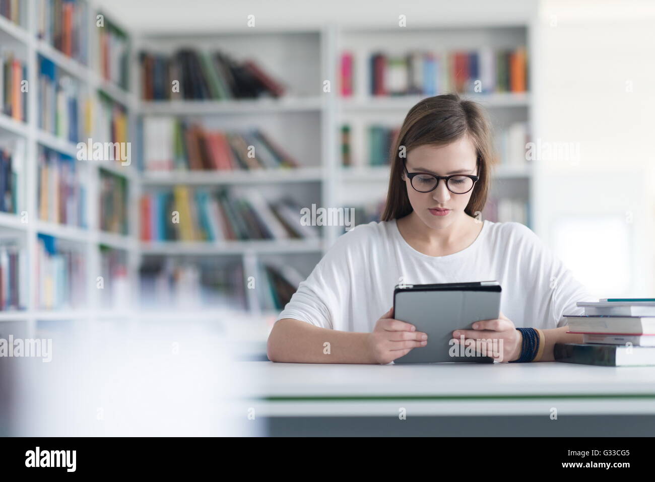 female student study in school library, using tablet and searching for ...