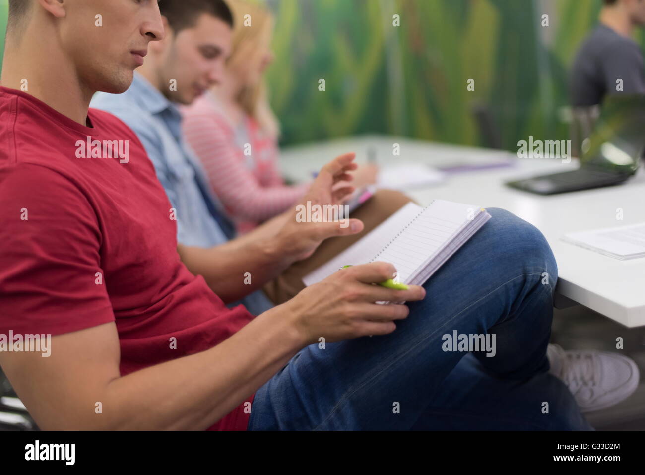 male student taking notes in classroom. business education concept ...