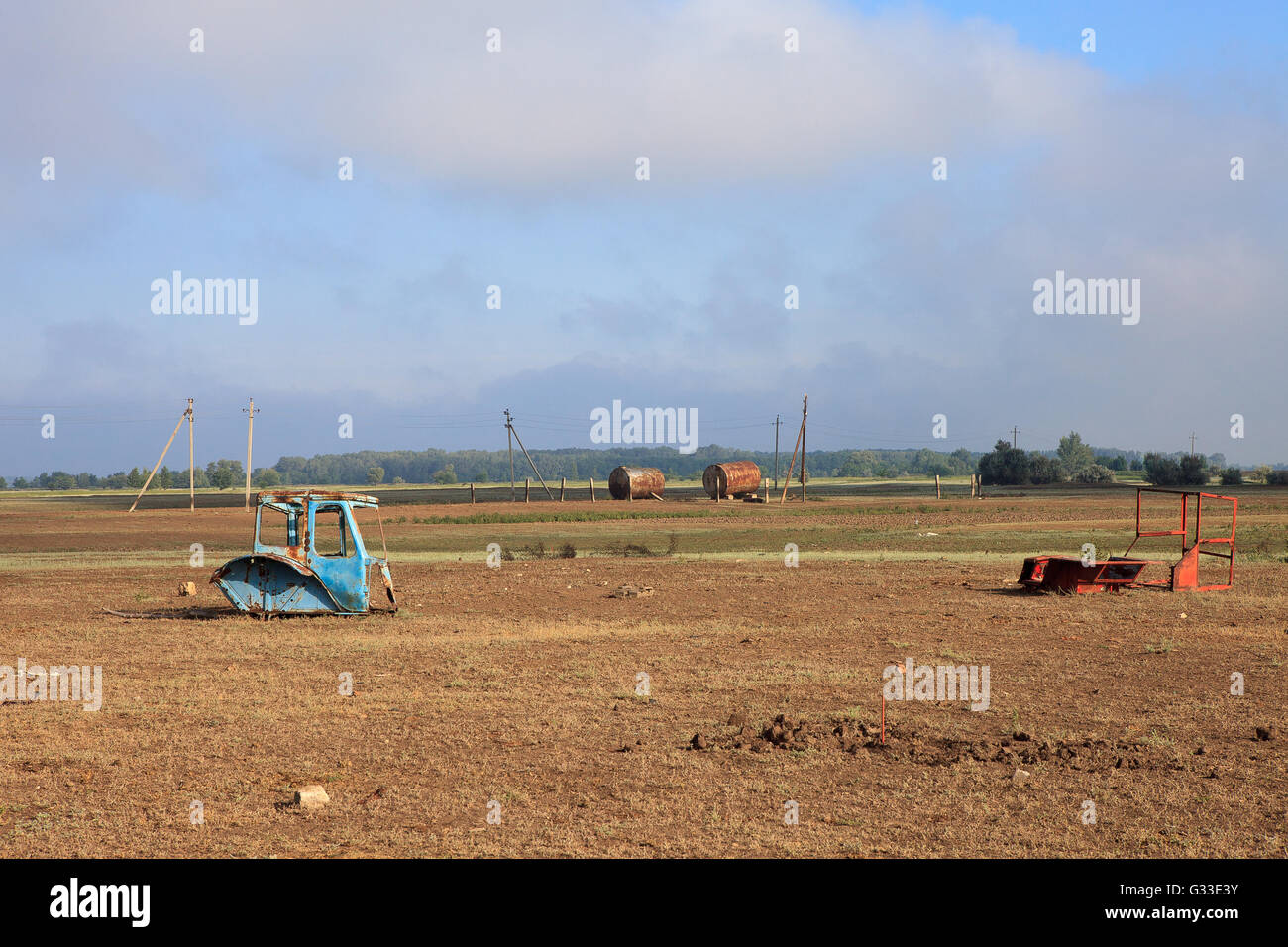 Abandoned farm equipment, field, barn. The landscape of the Russian ...