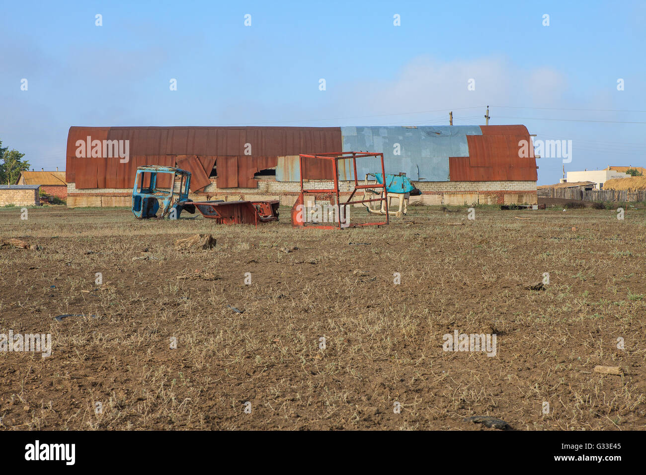 Abandoned farm equipment, field, barn. The landscape of the Russian ...