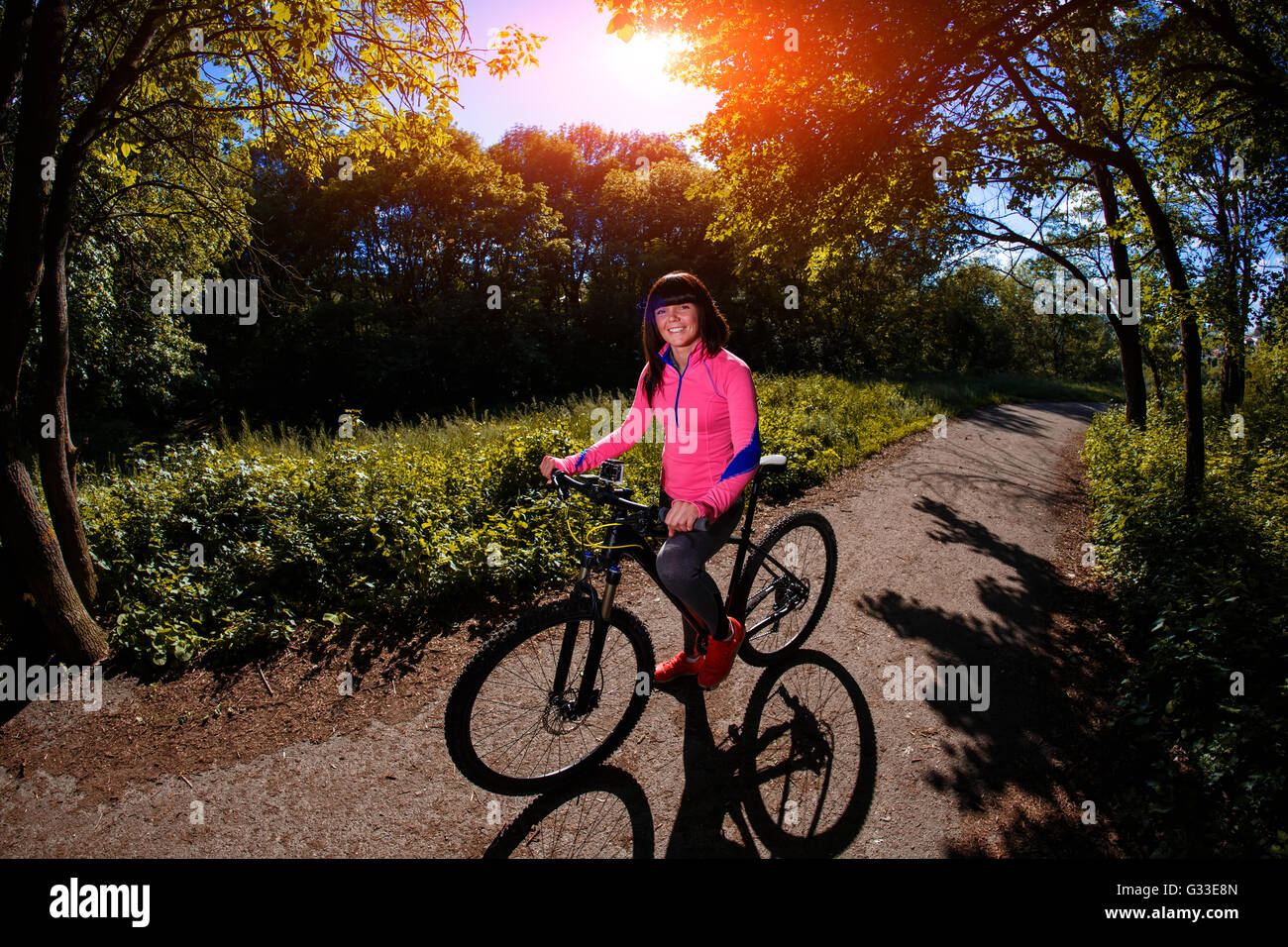 Young woman having fun riding a bicycle in the park Stock Photo - Alamy