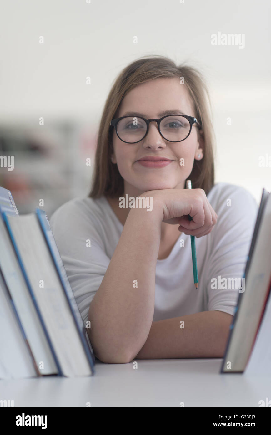 portrait of smart looking famale student girl in collage school library ...
