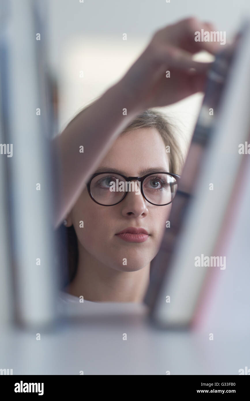 portrait of smart looking famale student girl in collage school library ...