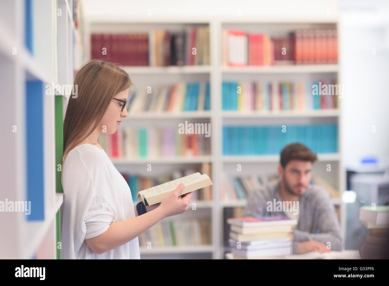 happy students couple in school library have discussion about book ...