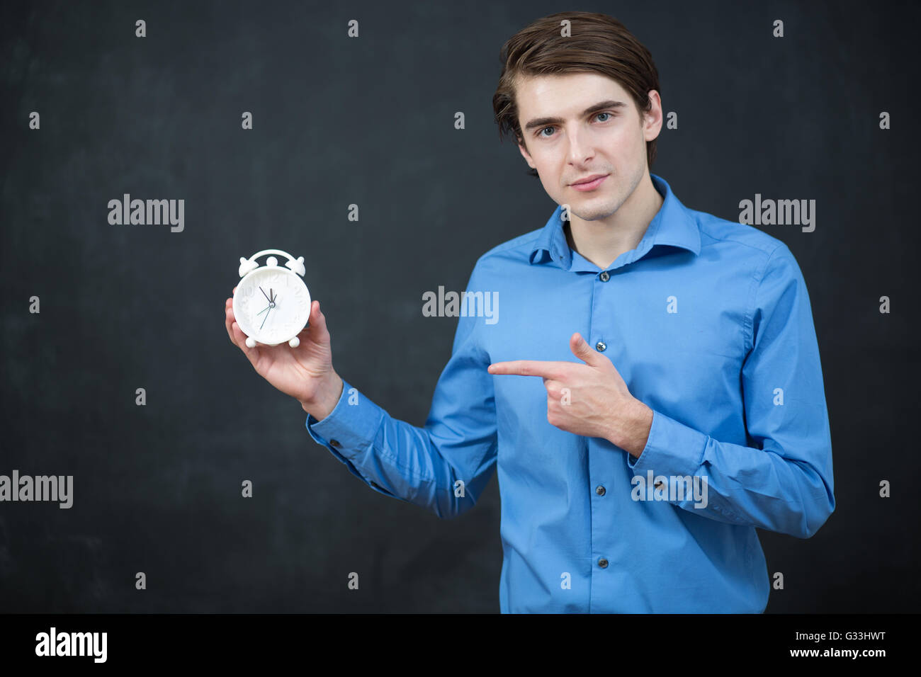 time. man is looking at clock with chalk board behind him Stock Photo ...