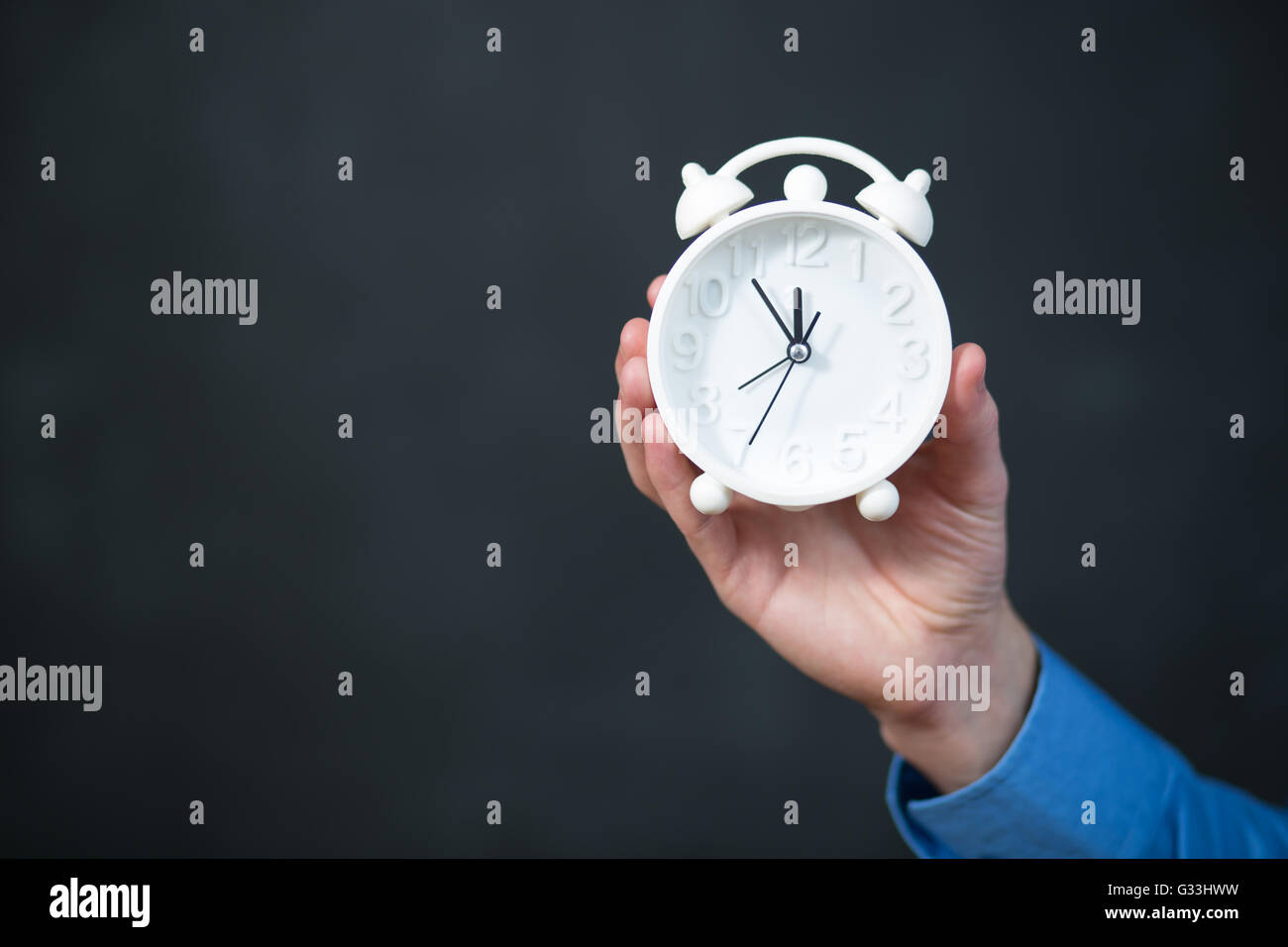 time. man is looking at clock with chalk board behind him Stock Photo ...